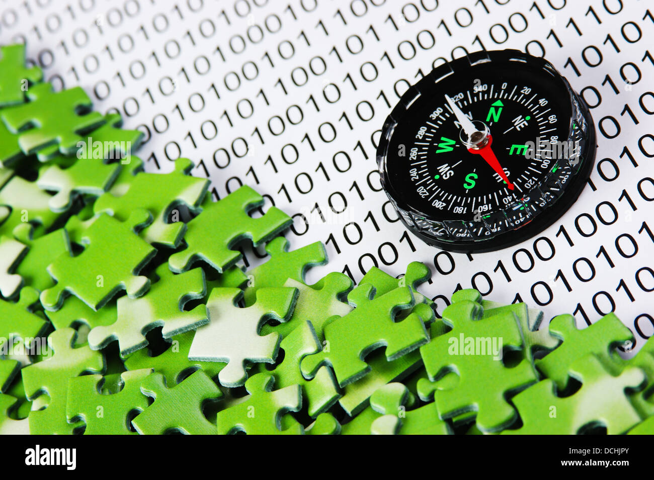 puzzles and compass on a binary code Stock Photo - Alamy