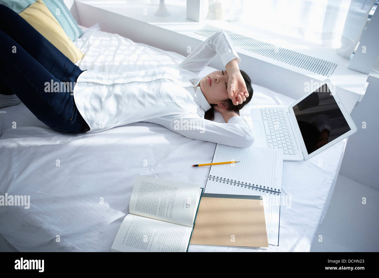 a student sleeping on bed while studying Stock Photo - Alamy