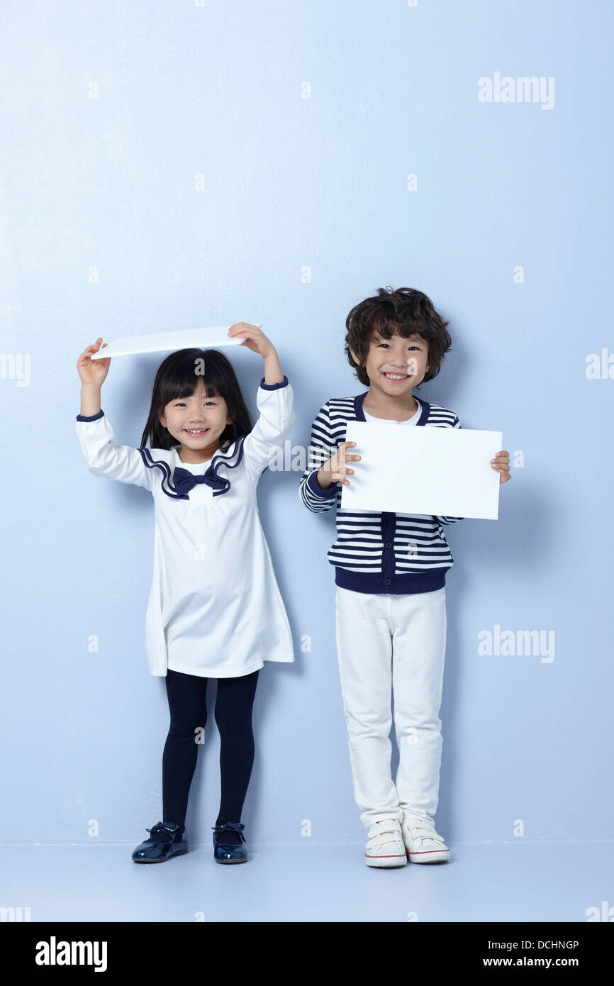 brother and sister holding blank papers Stock Photo - Alamy
