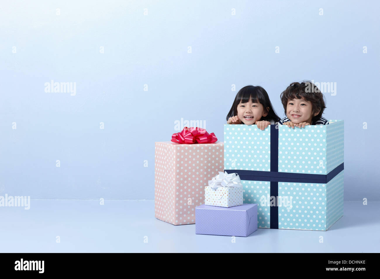 a brother and a sister inside a present Stock Photo - Alamy