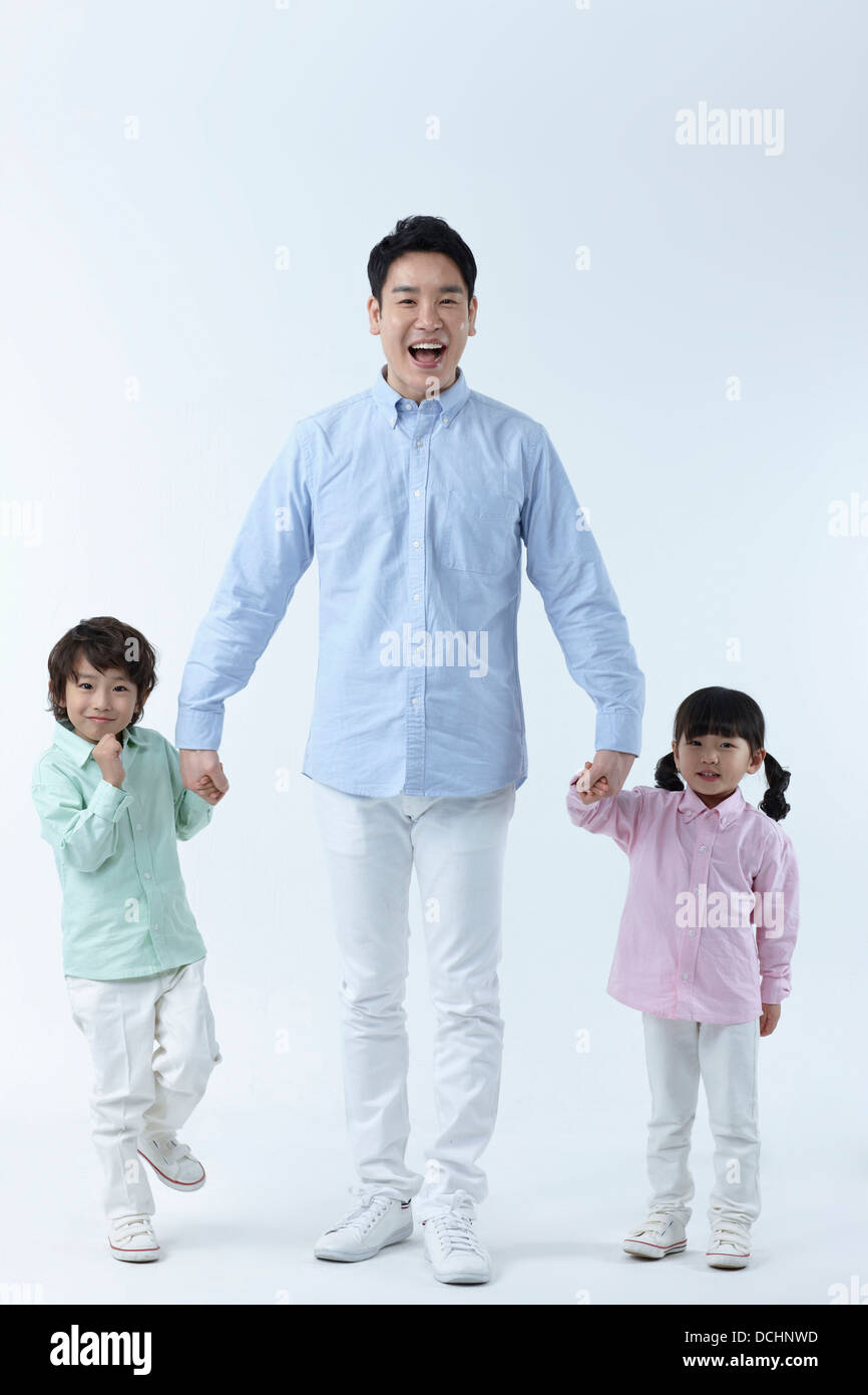 a father walking hand in hand with kids Stock Photo - Alamy