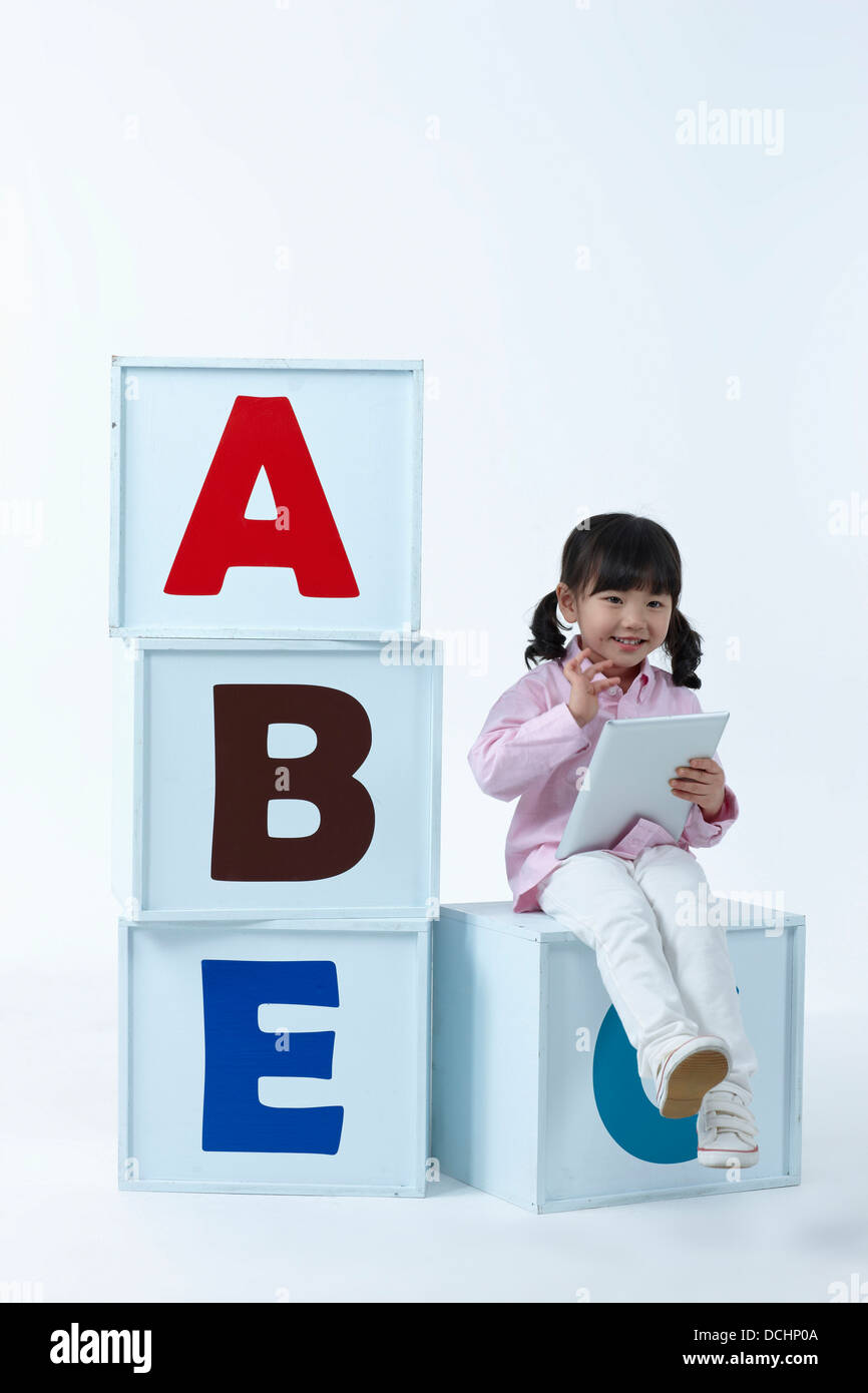 a girl sitting on boxes with alphabets Stock Photo - Alamy
