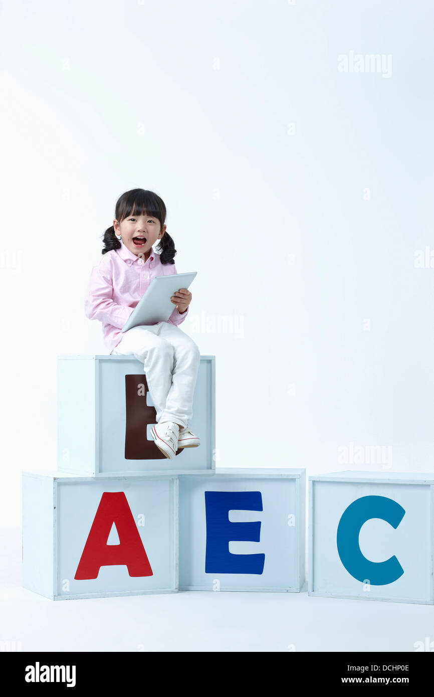 a girl sitting on boxes with alphabets Stock Photo - Alamy