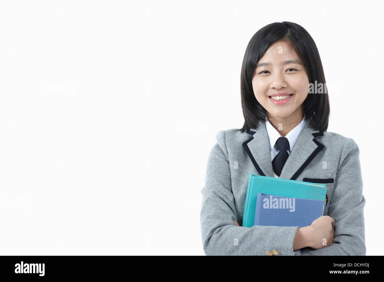 a girl in a school uniform holding books Stock Photo - Alamy