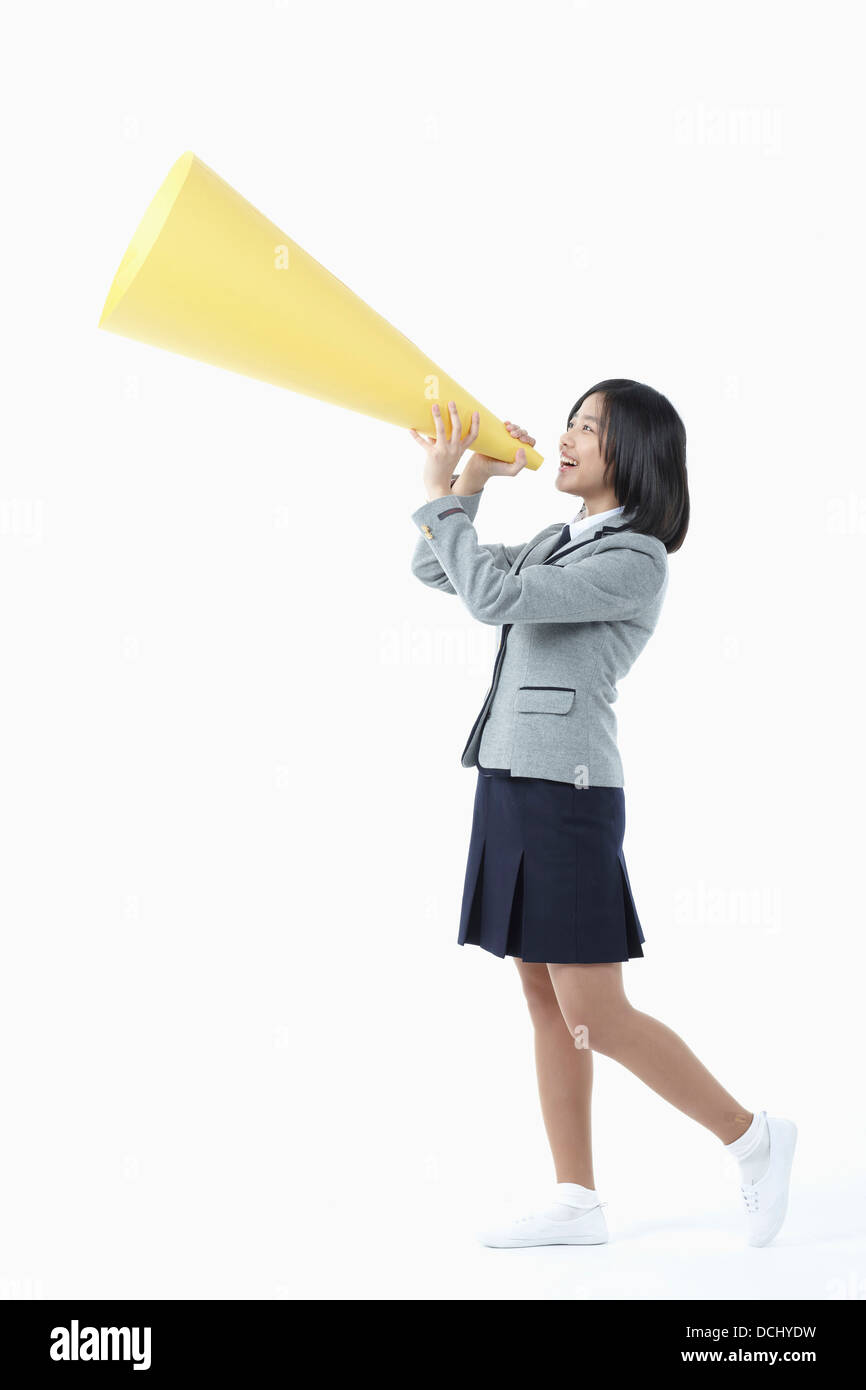 a girl in a school uniform holding a paper megaphone Stock Photo - Alamy