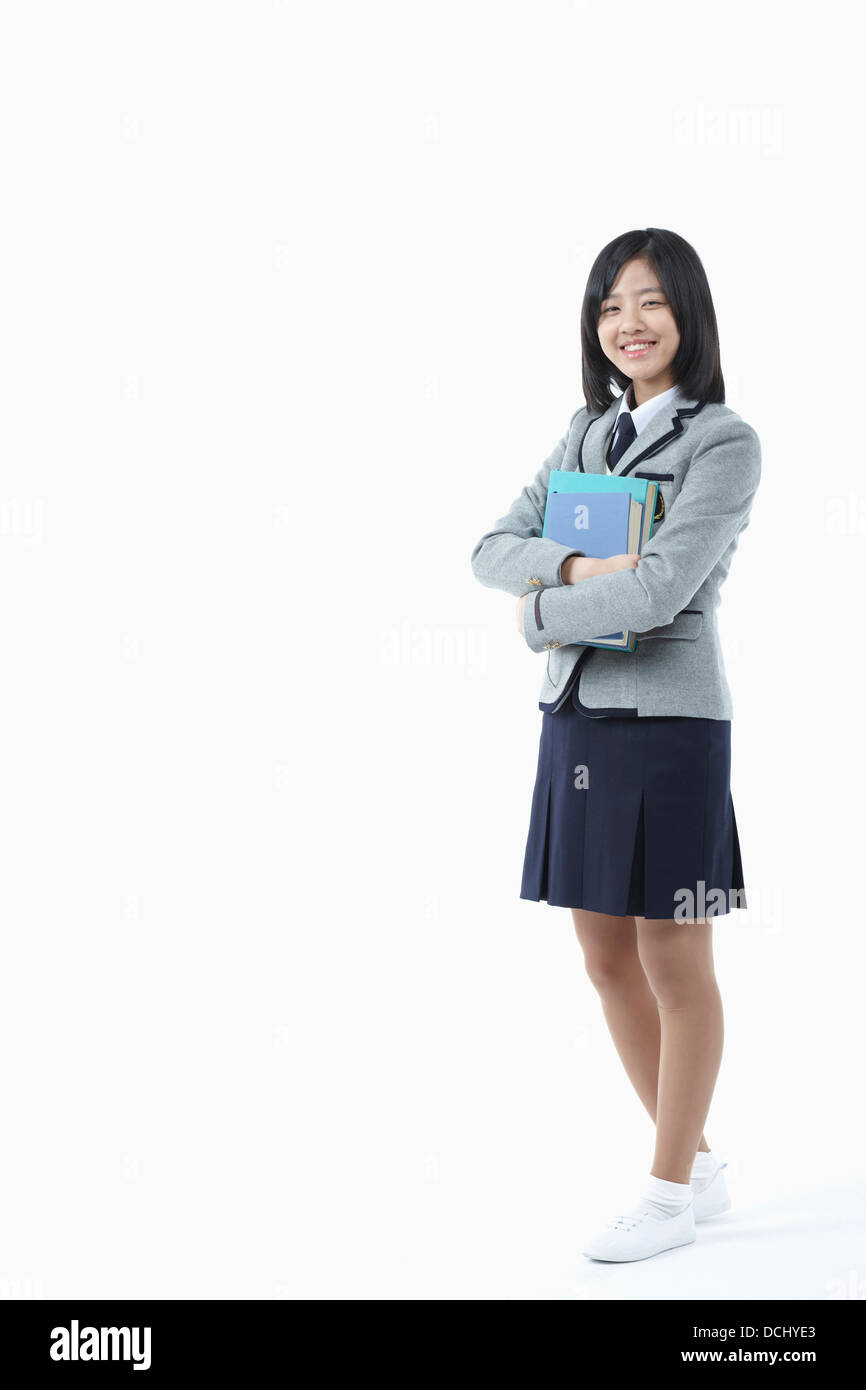 a girl in a school uniform holding books Stock Photo - Alamy
