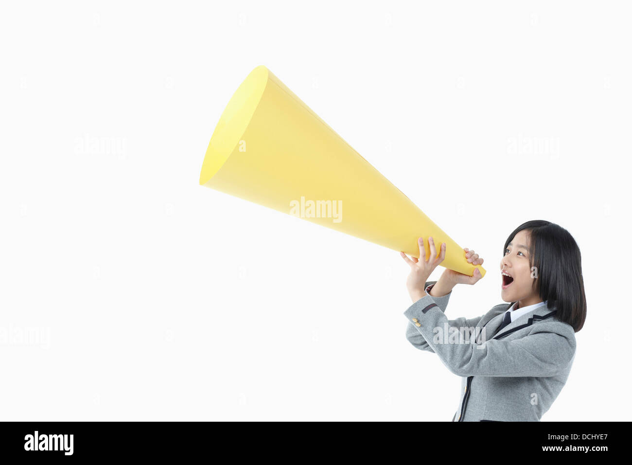 a girl in a school uniform holding a paper megaphone Stock Photo - Alamy