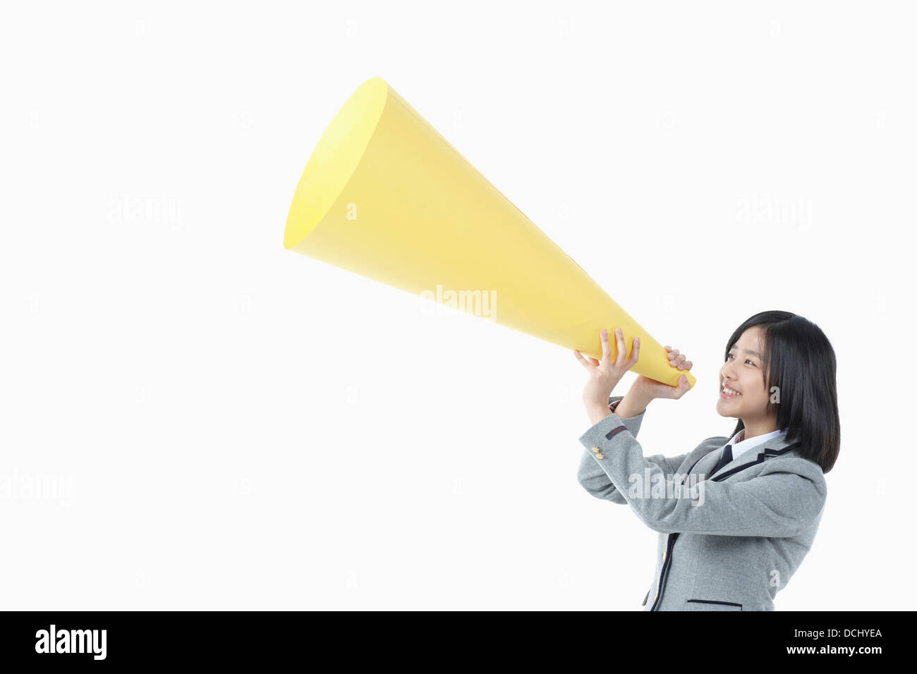 a girl in a school uniform holding a paper megaphone Stock Photo - Alamy