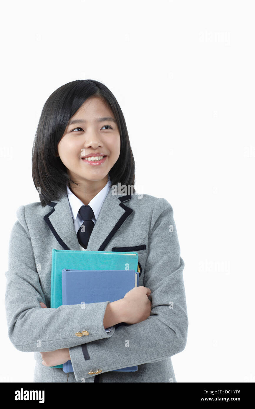 a girl in a school uniform holding books Stock Photo - Alamy