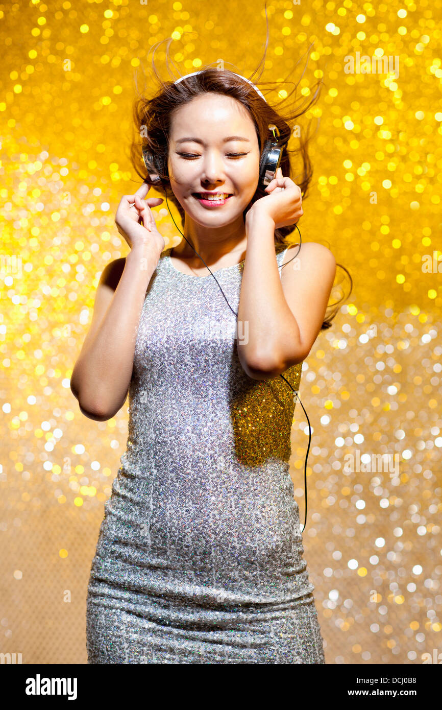a woman in fancy dress listening to music with headphone Stock Photo ...