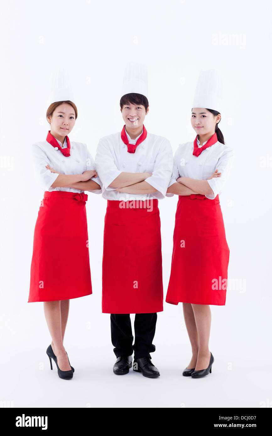 three cook with chef hats posing together in white background Stock ...