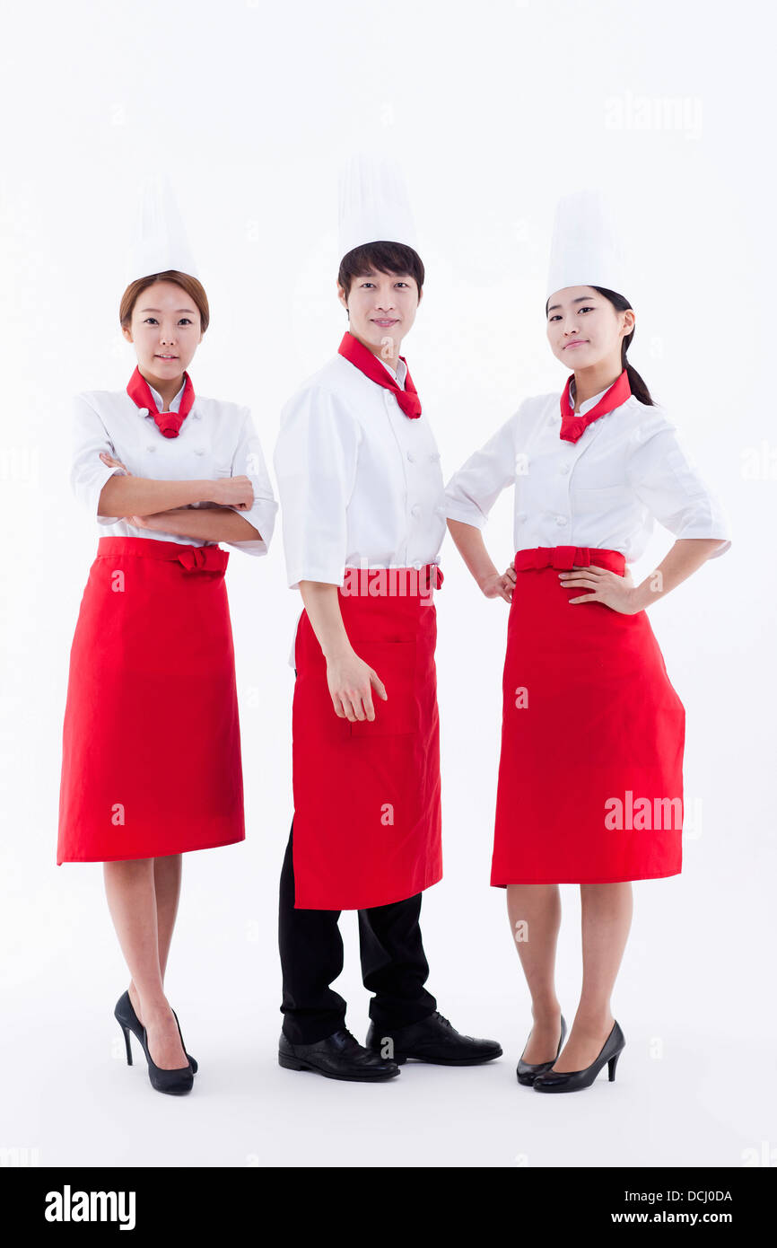 three cook with chef hats posing together in white background Stock ...