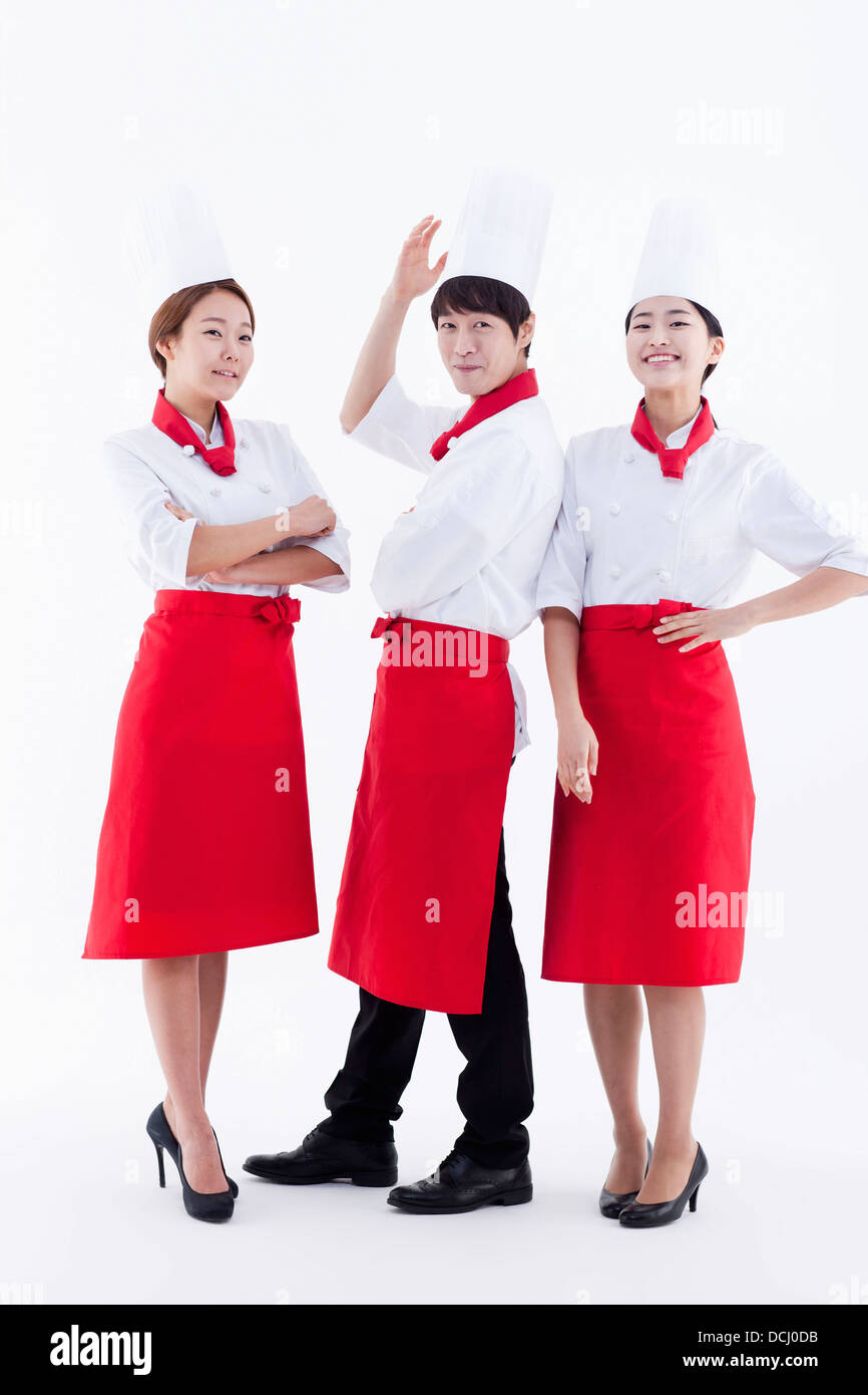 three cook with chef hats posing together in white background Stock ...