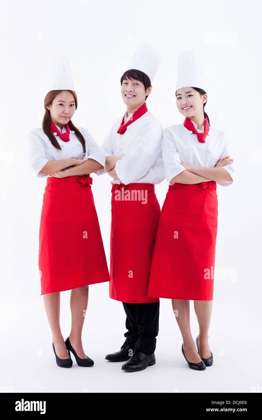three cook with chef hats posing together in white background Stock ...