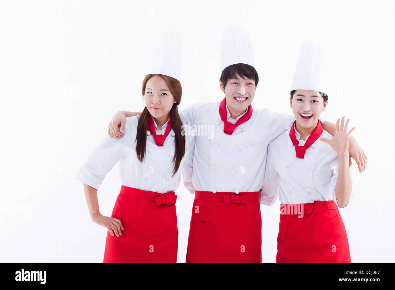 three cook with chef hats posing together in white background Stock ...