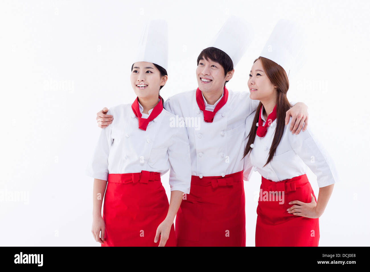 three cook with chef hats looking at same place Stock Photo - Alamy