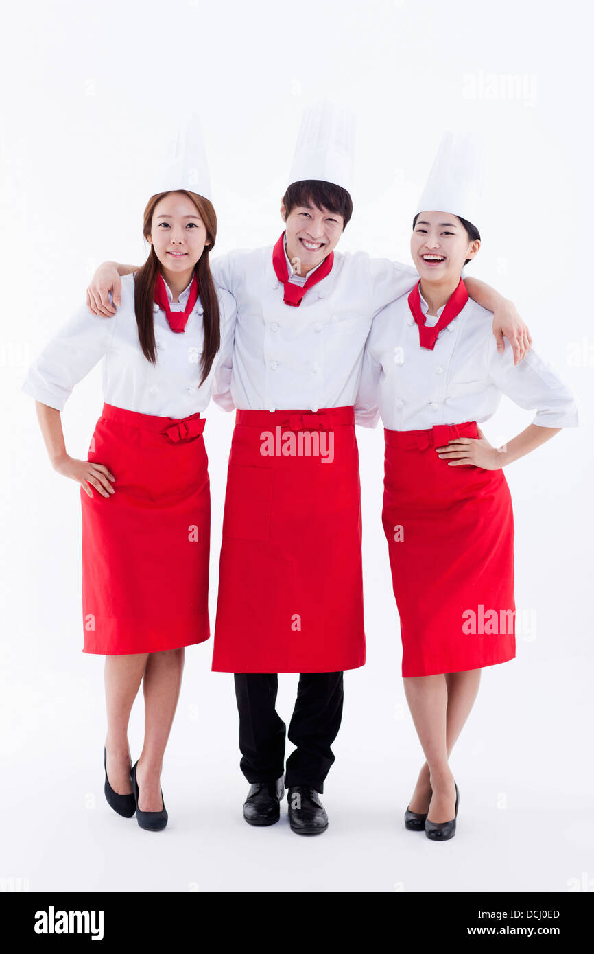 three cook with chef hats posing together in white background Stock ...