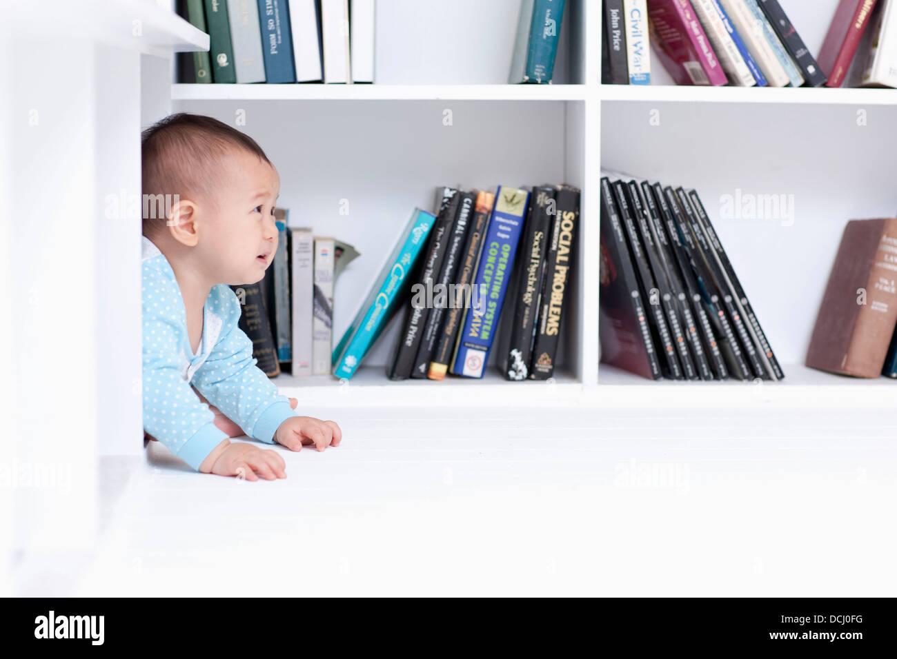 a baby crawling under a desk Stock Photo - Alamy