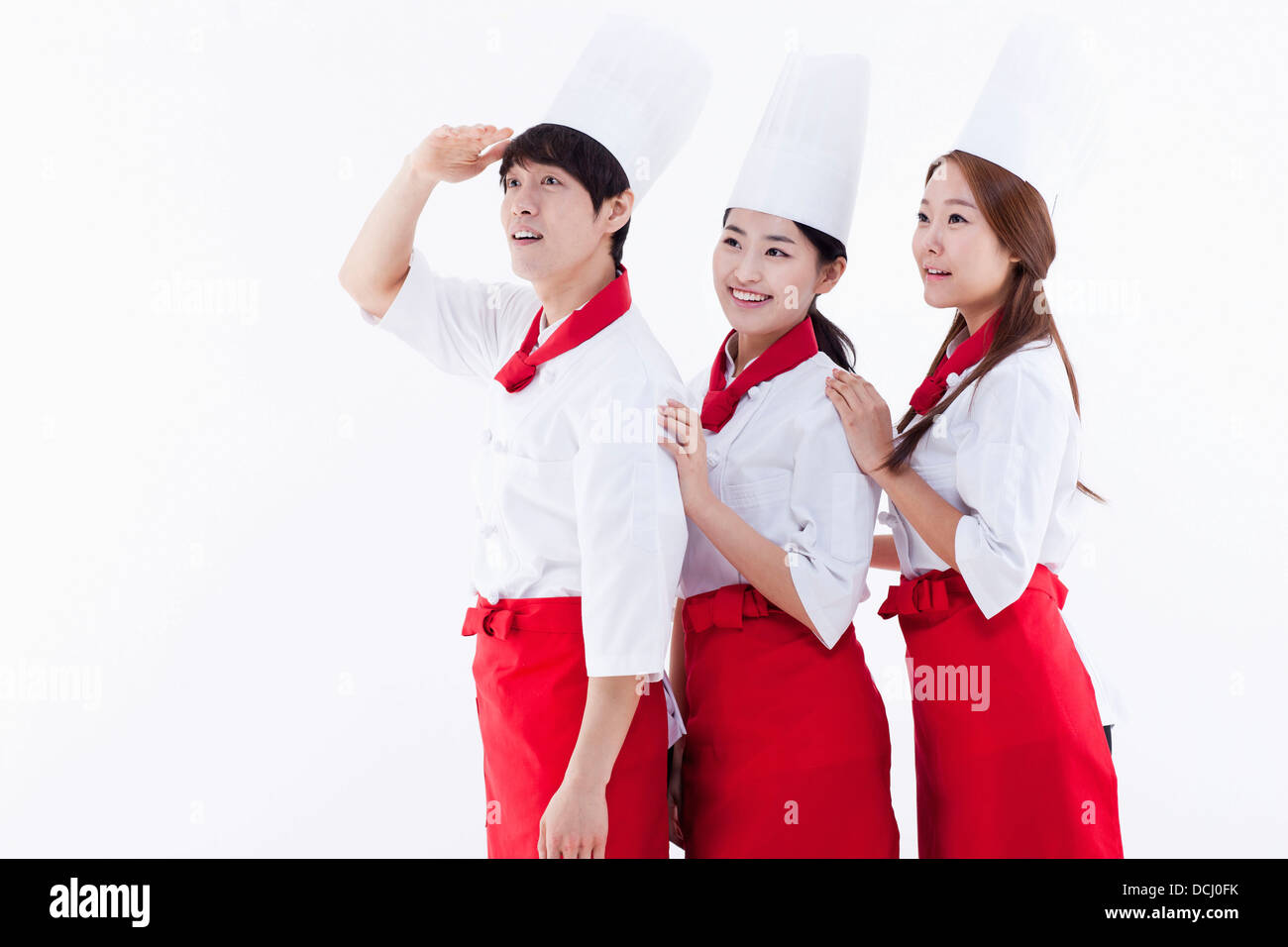 three cook with chef hats looking at same place Stock Photo - Alamy