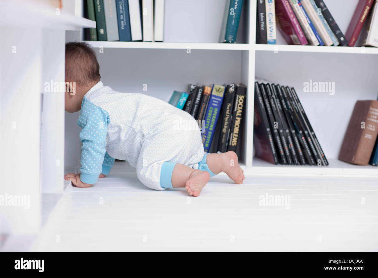 a baby crawling under a desk Stock Photo - Alamy
