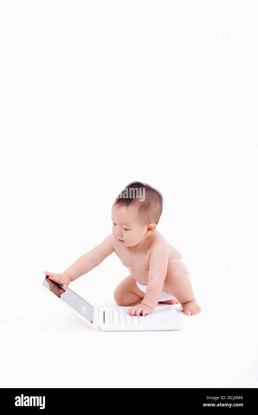 a baby in diaper playing with a laptop Stock Photo - Alamy