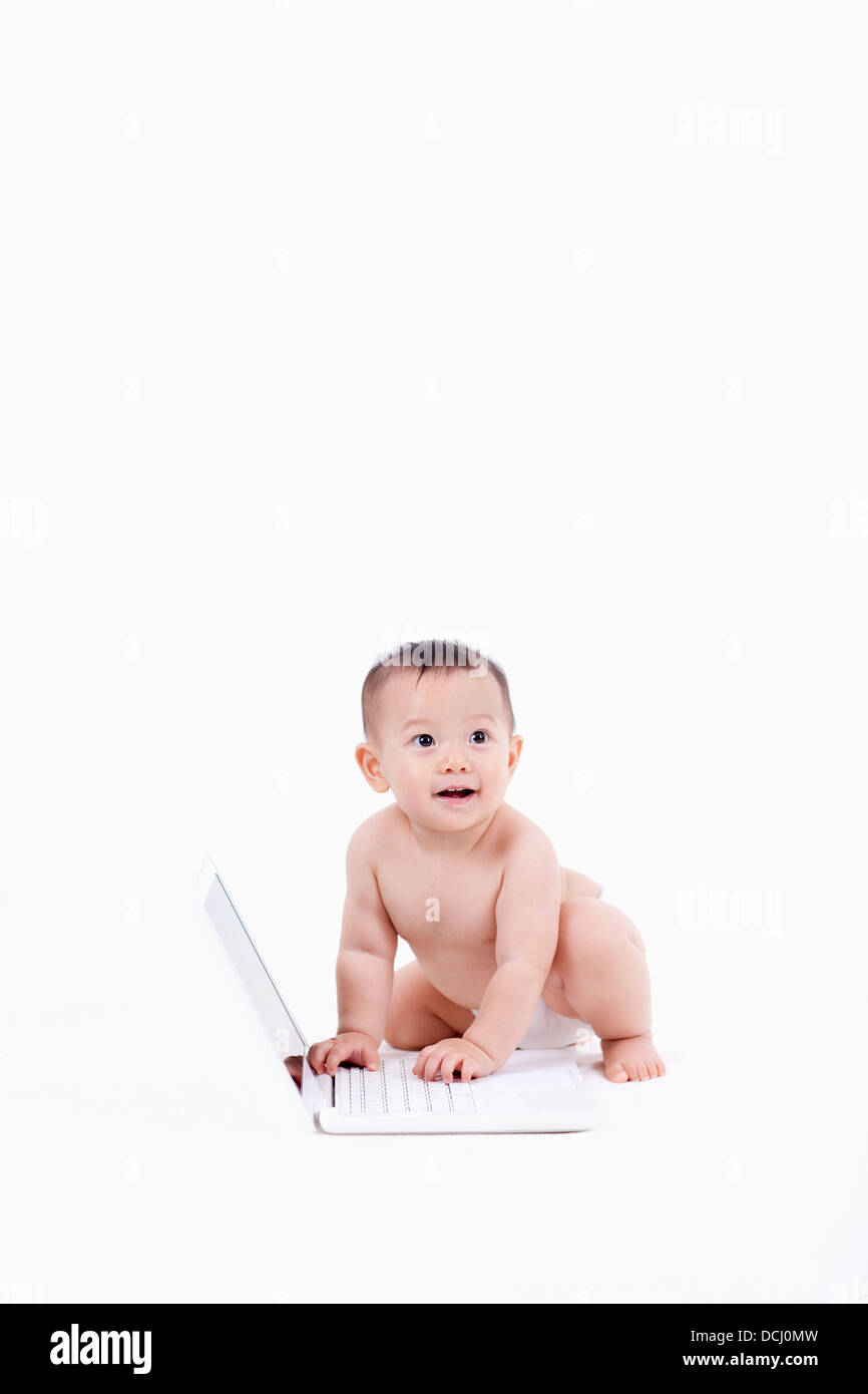 a baby in diaper playing with a laptop Stock Photo - Alamy