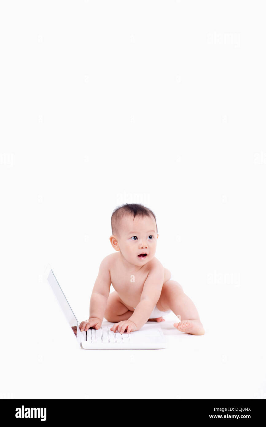 a baby in diaper playing with a laptop Stock Photo - Alamy
