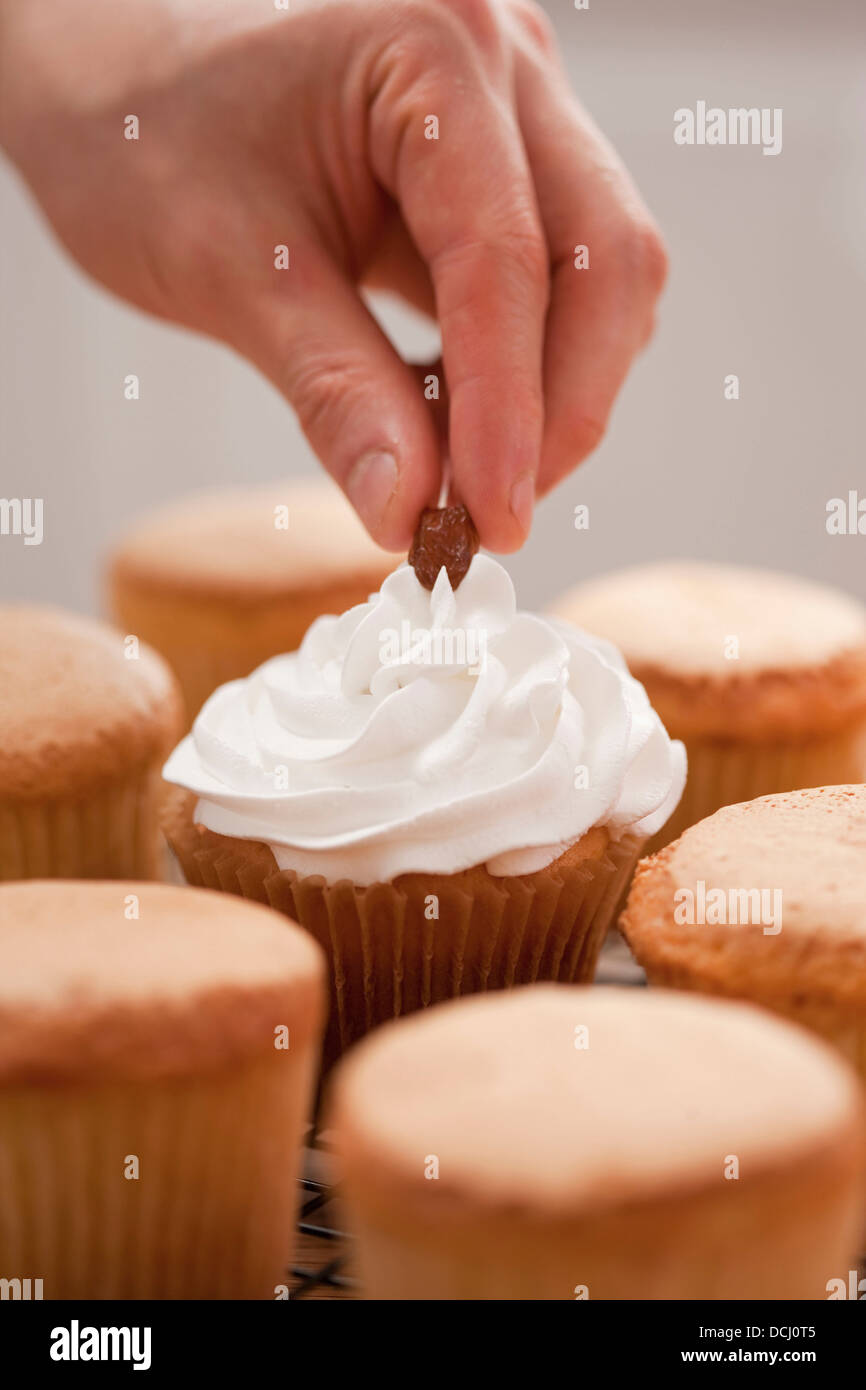 putting almond on cup cake Stock Photo - Alamy