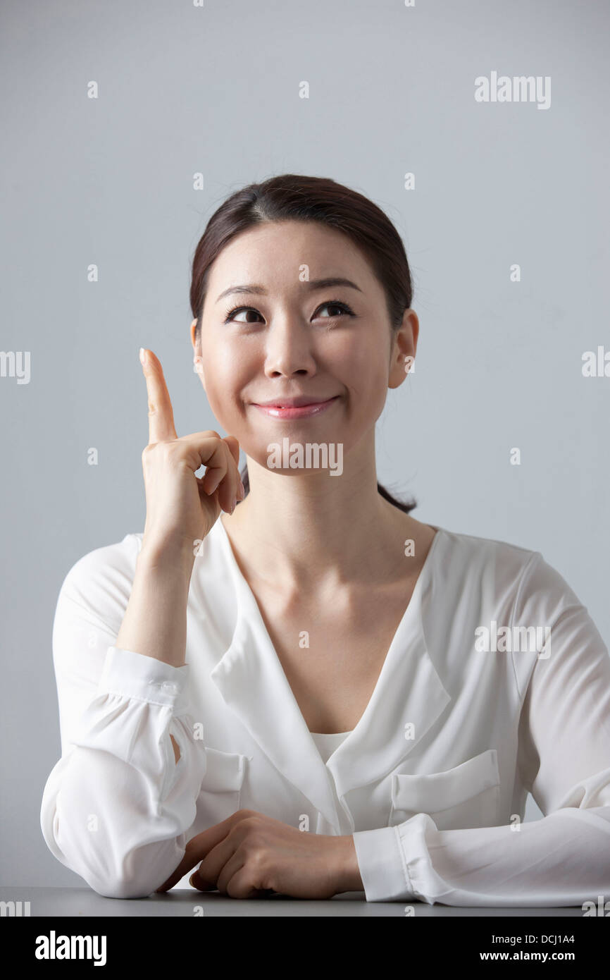 a woman thinking while sitting at a desk Stock Photo - Alamy