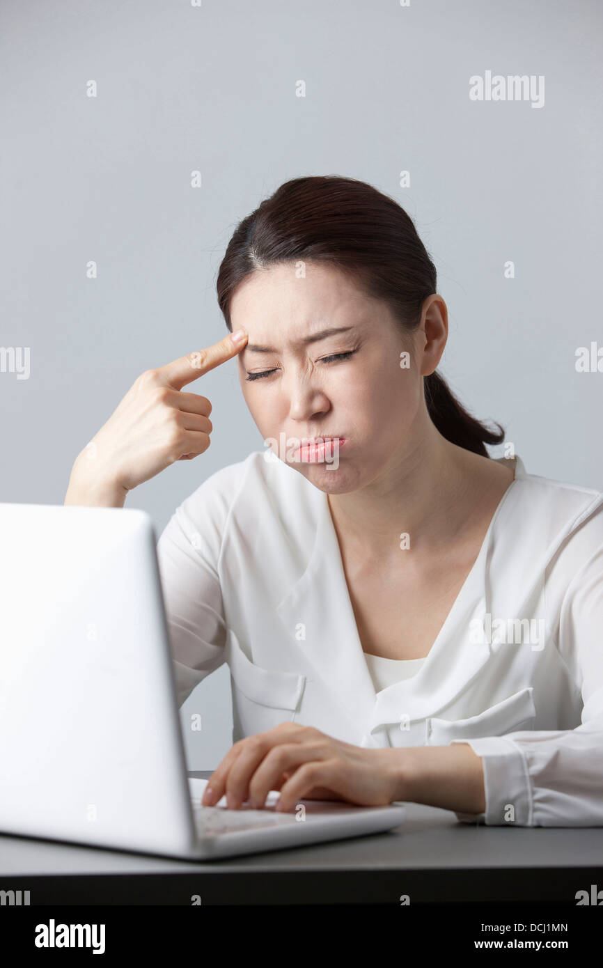 a woman thinking while using a laptop Stock Photo - Alamy