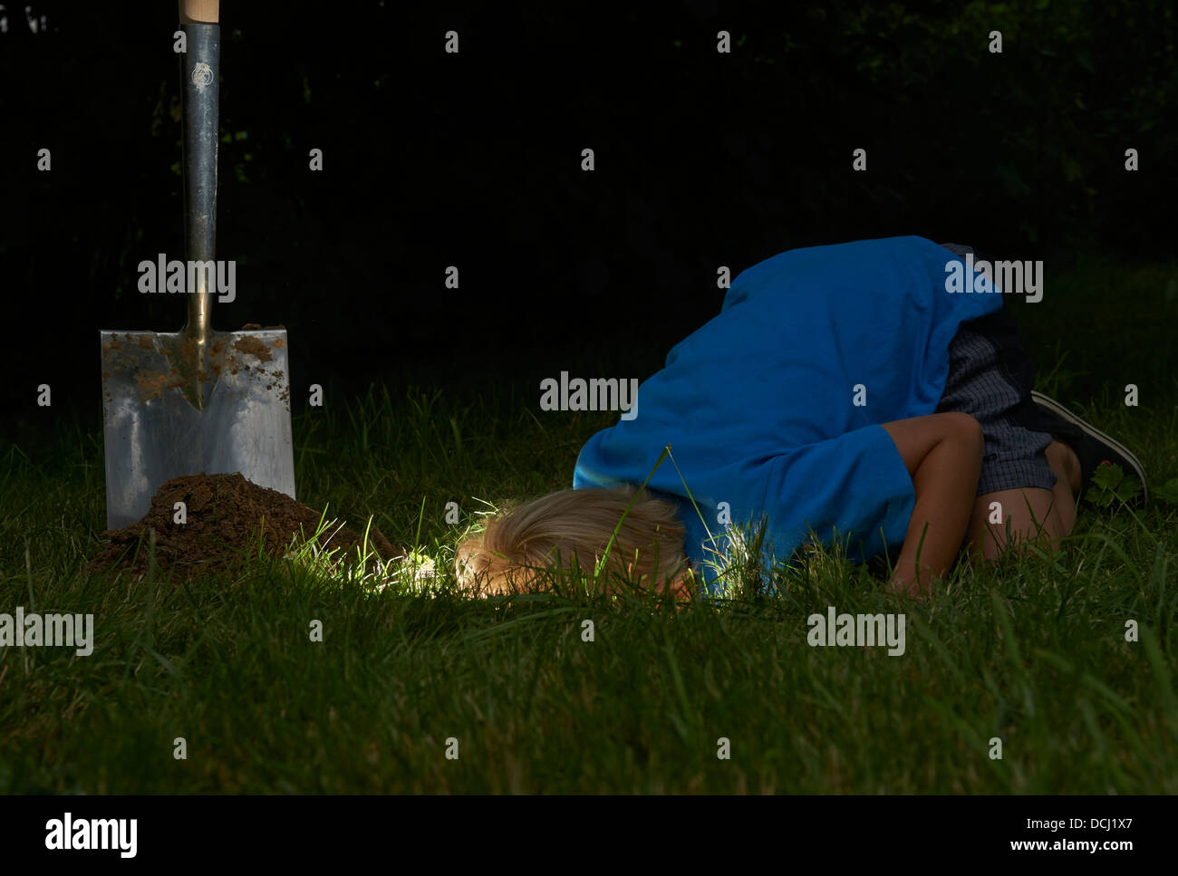 Child boy digging a treasure in magic hole in soil at dusk Stock Photo ...