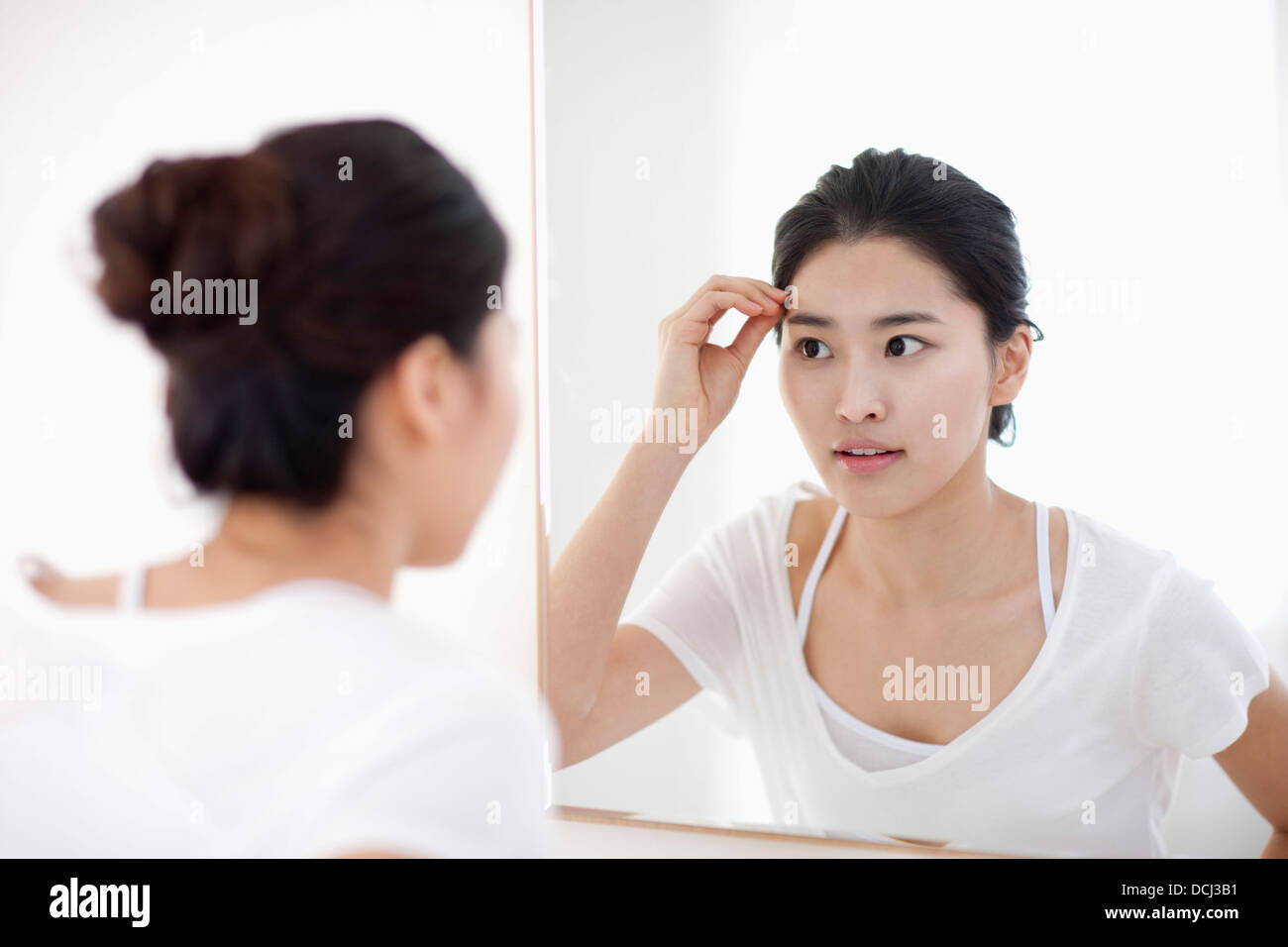 a woman checking her face skin Stock Photo - Alamy
