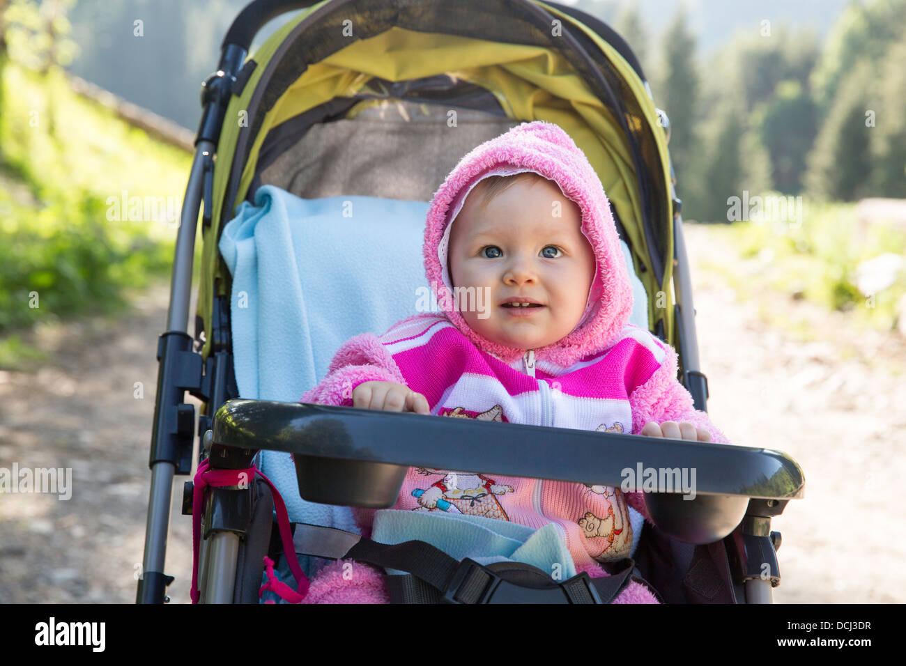 Smiling pretty little child girl in buggy on nature Stock Photo - Alamy