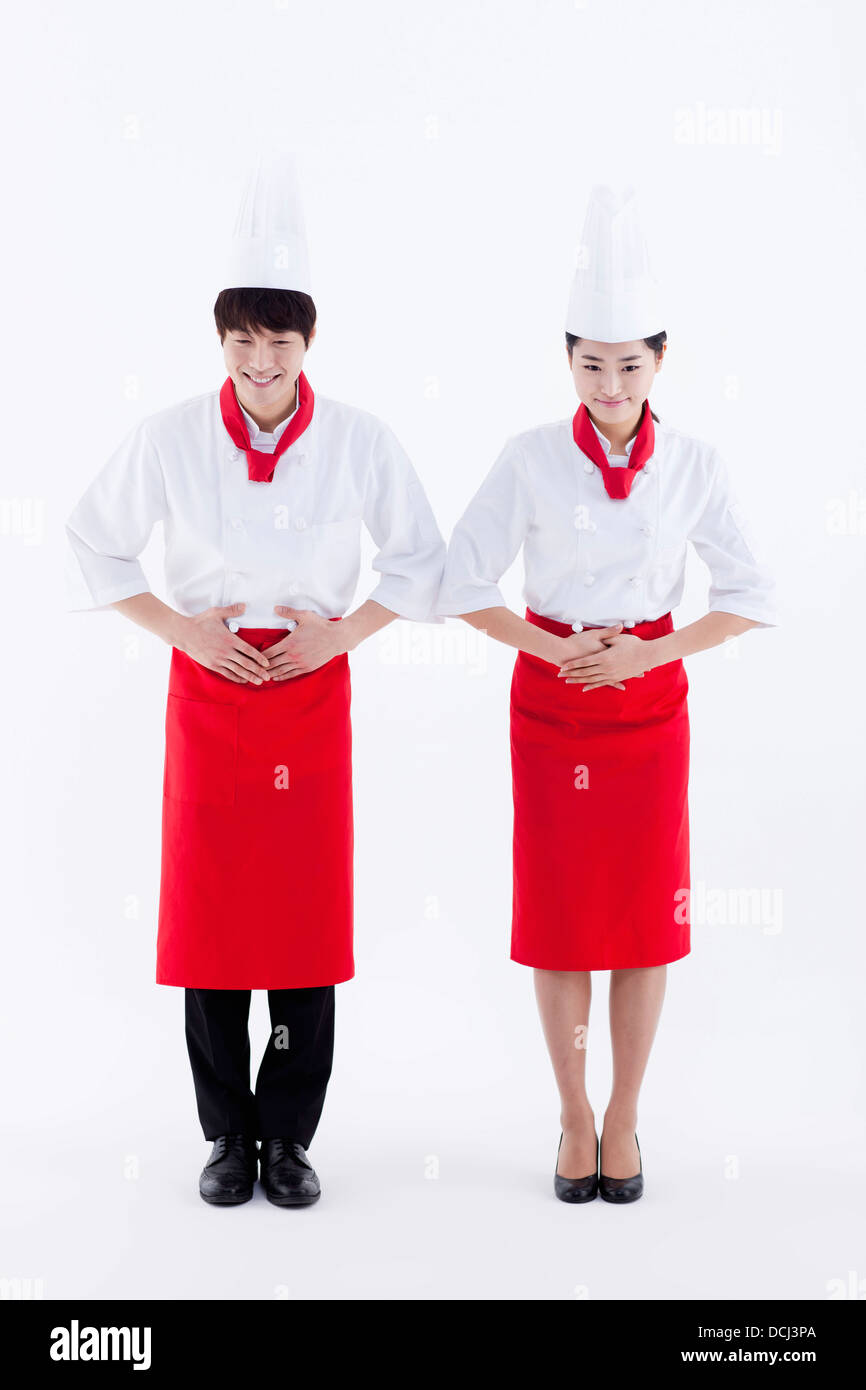 female and male cook in red apron bowing politely Stock Photo - Alamy