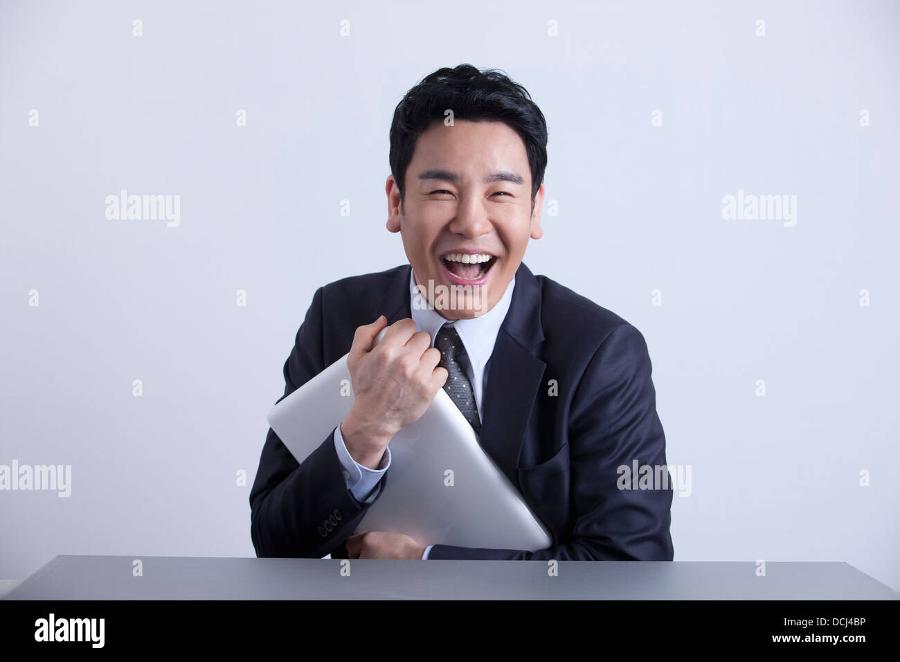 a businessman happily hugging a laptop Stock Photo - Alamy