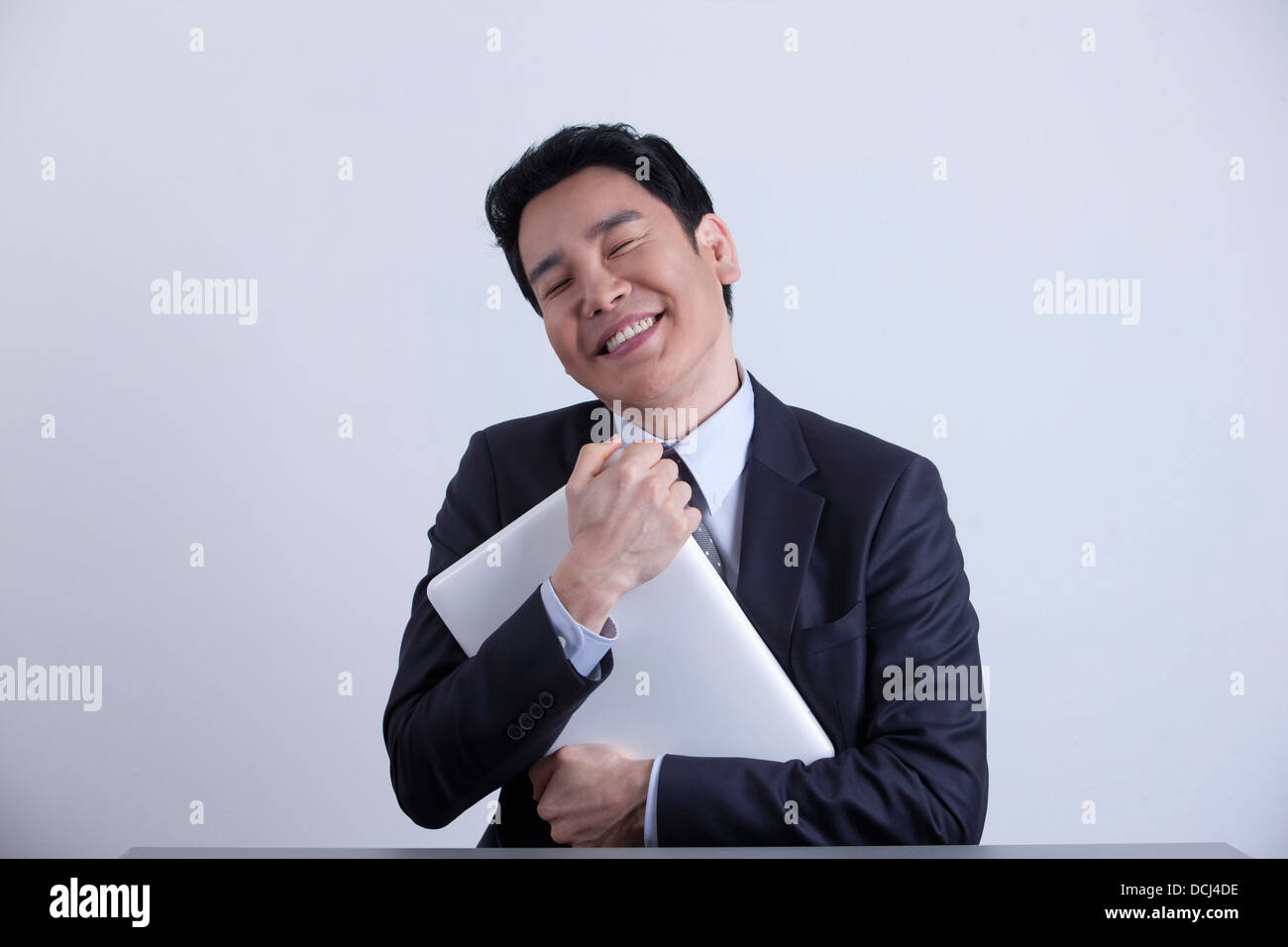 a businessman happily hugging a laptop Stock Photo - Alamy