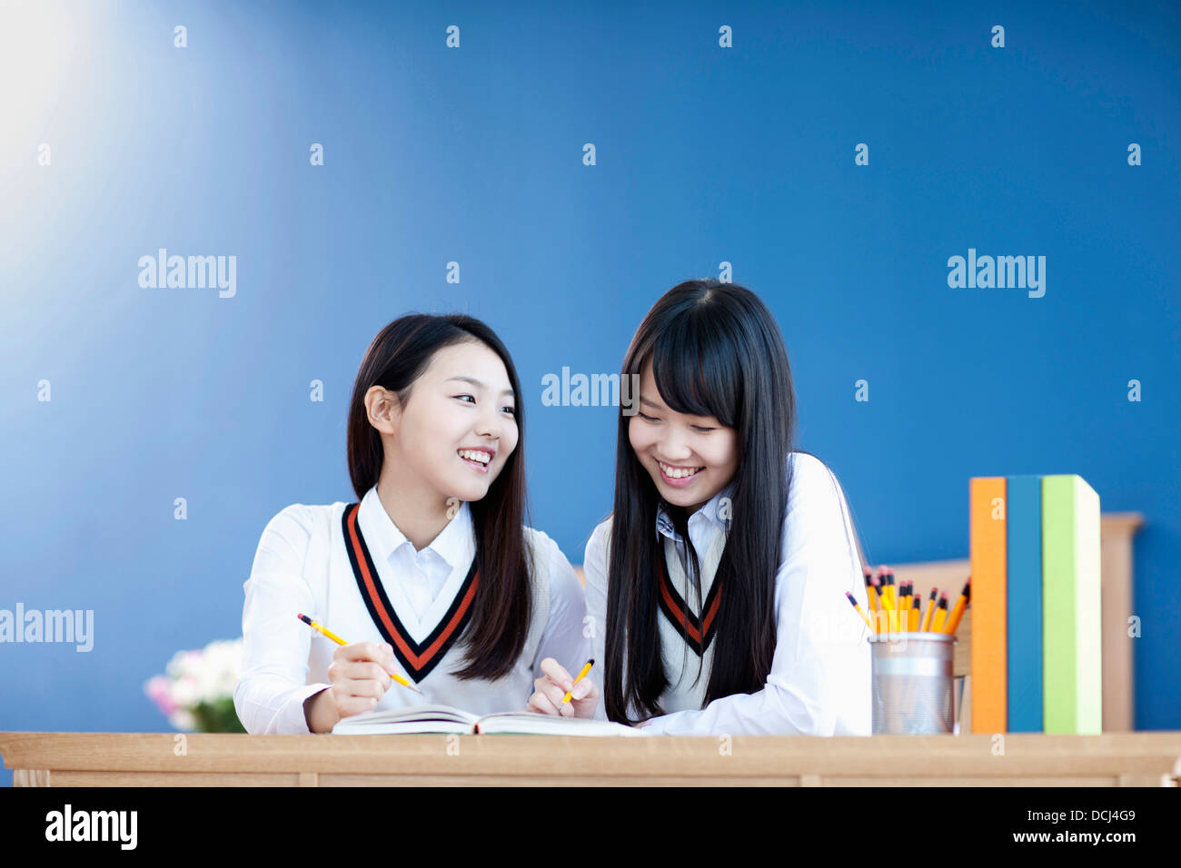 students in uniform at a desk studying together Stock Photo - Alamy