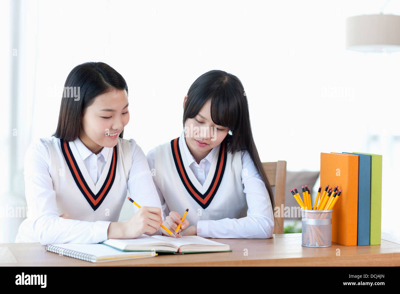 students in uniform at a desk studying together Stock Photo - Alamy