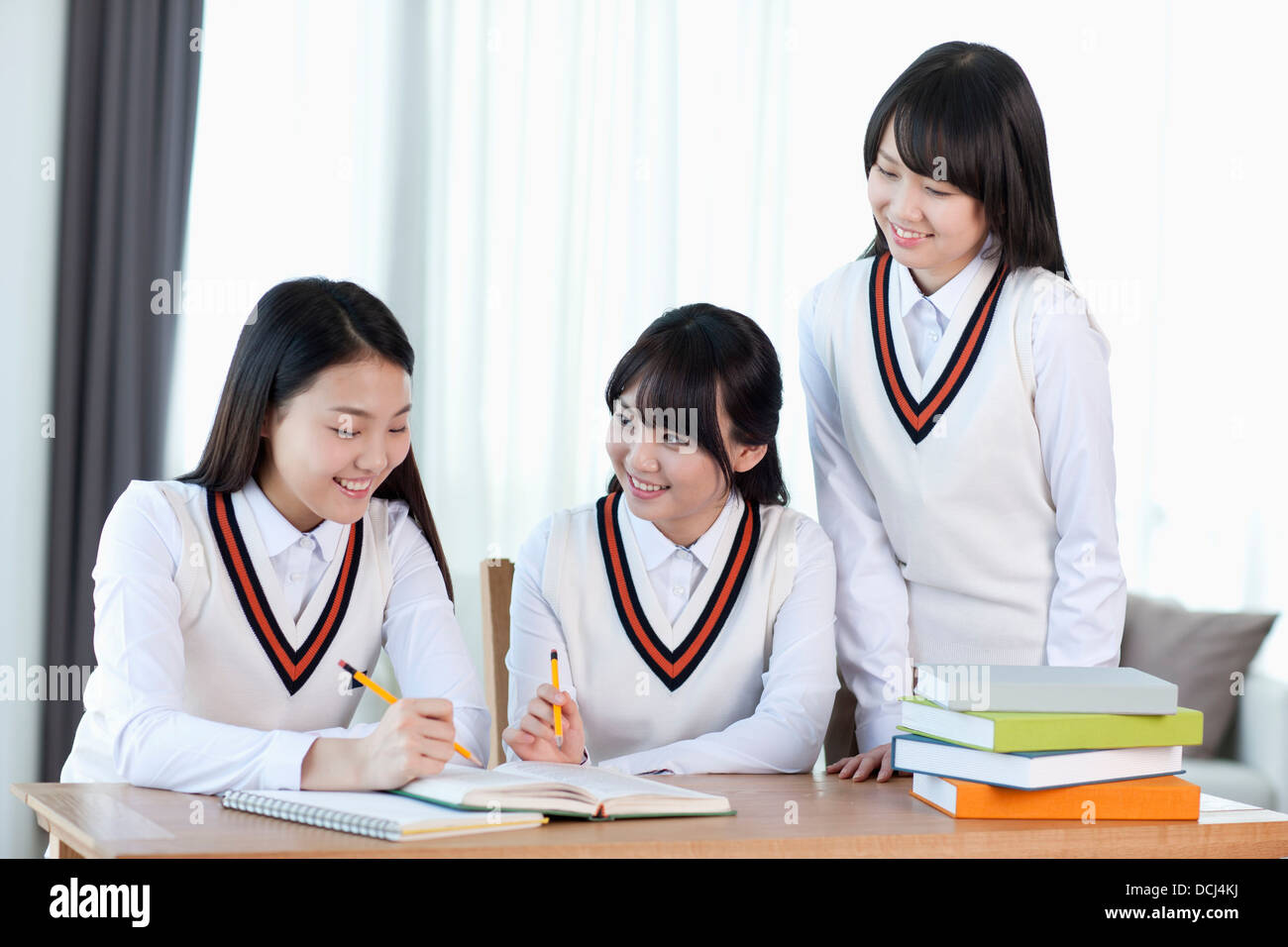 students in uniform at a desk studying together Stock Photo - Alamy