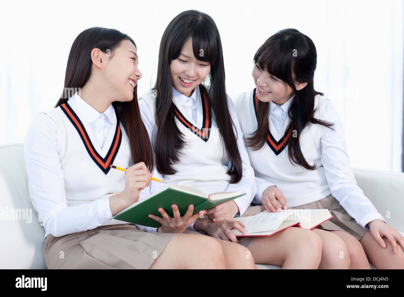 students in uniform sitting on a couch Stock Photo - Alamy