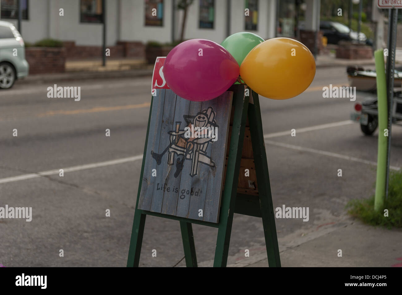 Balloons attached to a life is good sign outside a storefront within ...