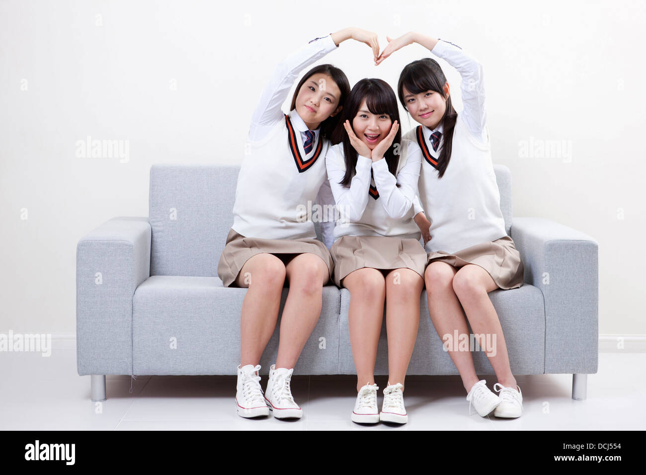 students in uniform sitting on a couch Stock Photo - Alamy