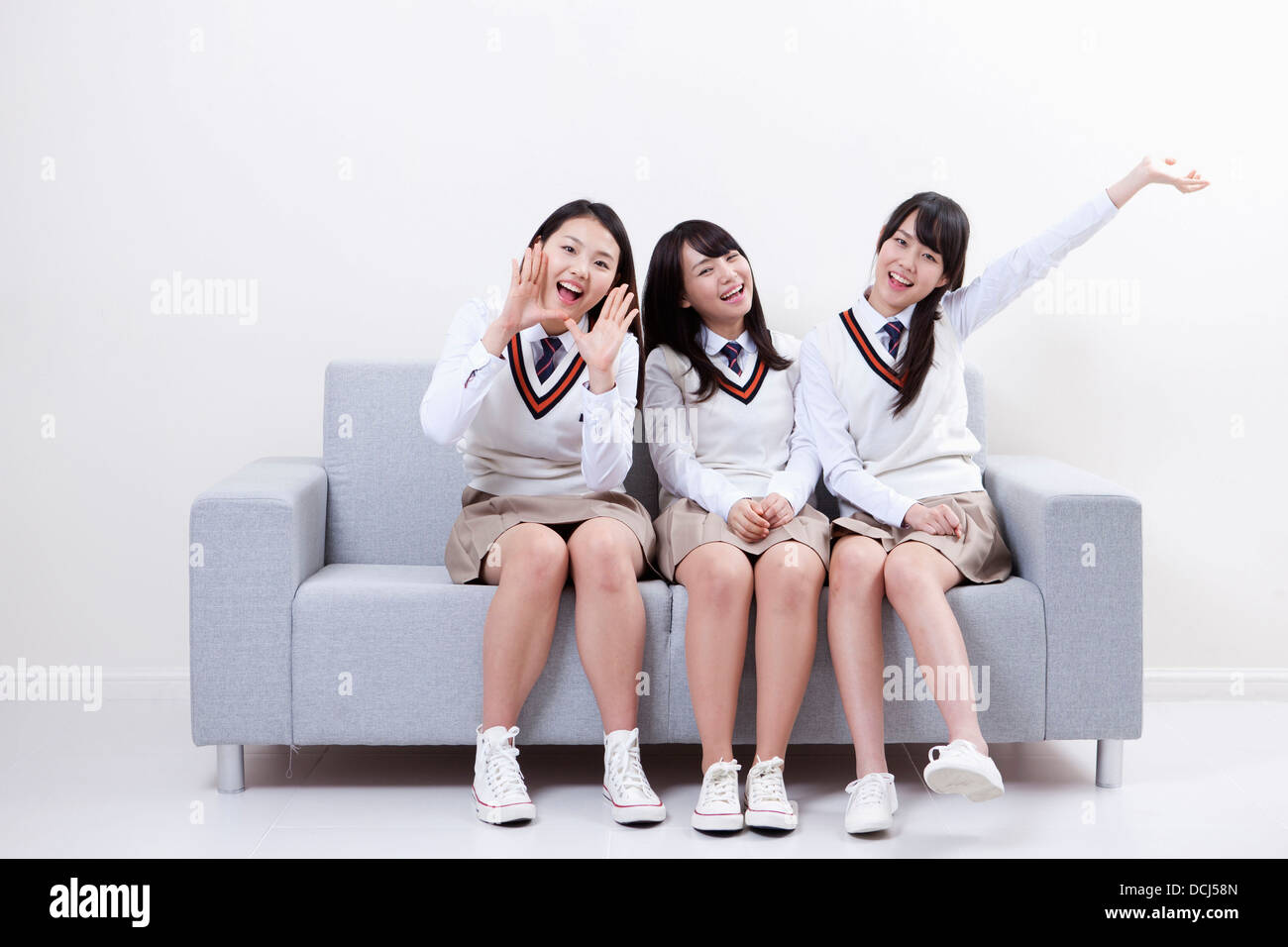 students in uniform sitting on a couch Stock Photo - Alamy