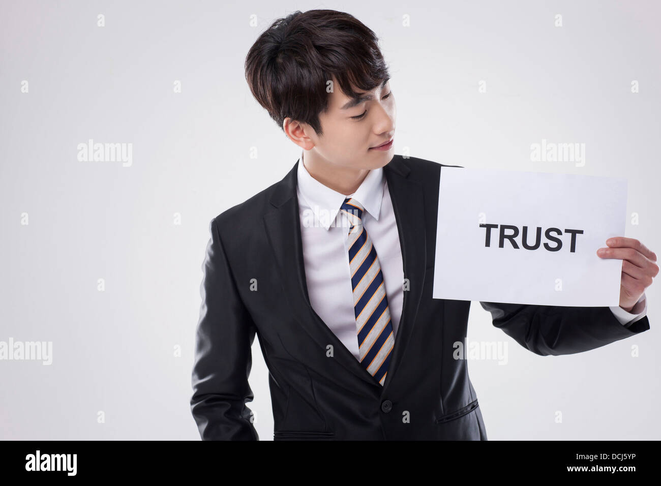 a business man with a paper saying trust Stock Photo - Alamy