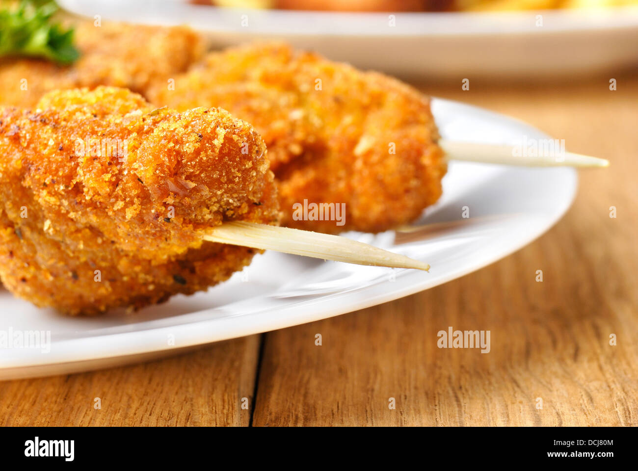 Tasty fried chicken kebab on the white plate on the wooden table Stock ...