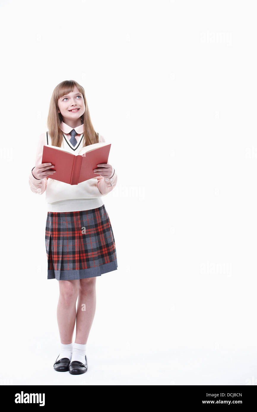 a student in uniform reading a book on white background Stock Photo - Alamy
