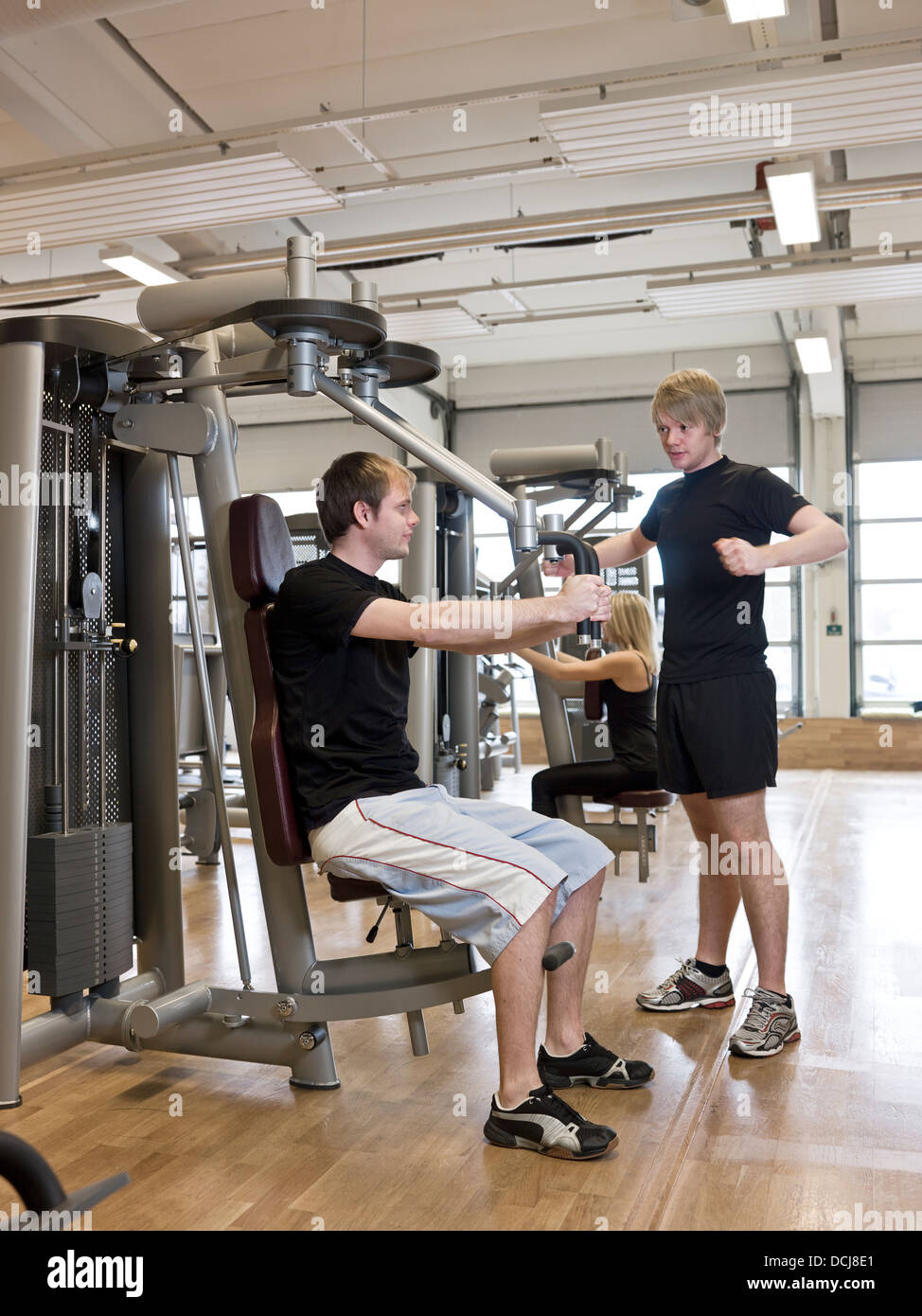Man instructing how to use an exercise machine Stock Photo - Alamy