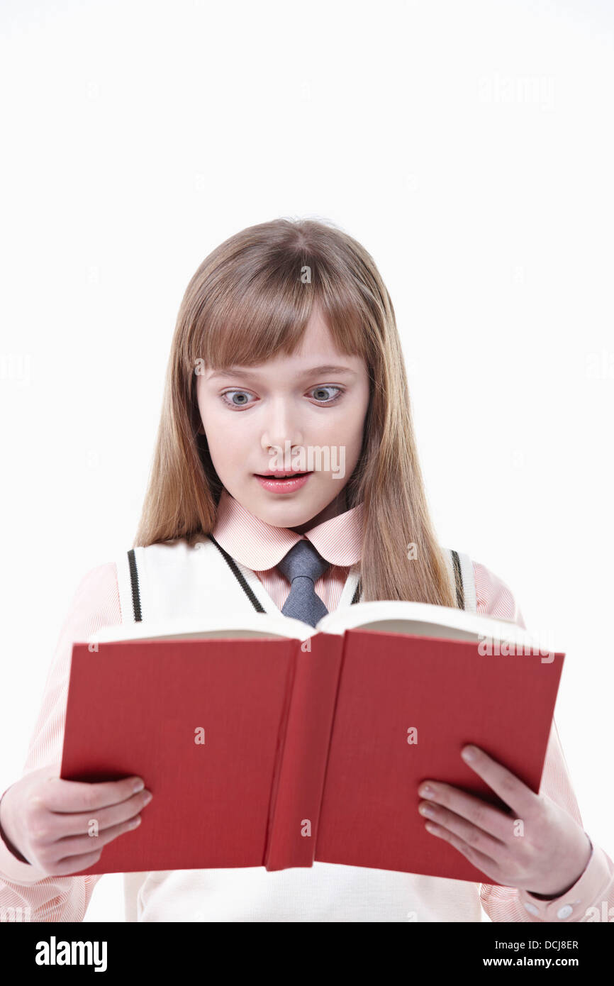 a student in uniform reading a book on white background Stock Photo - Alamy