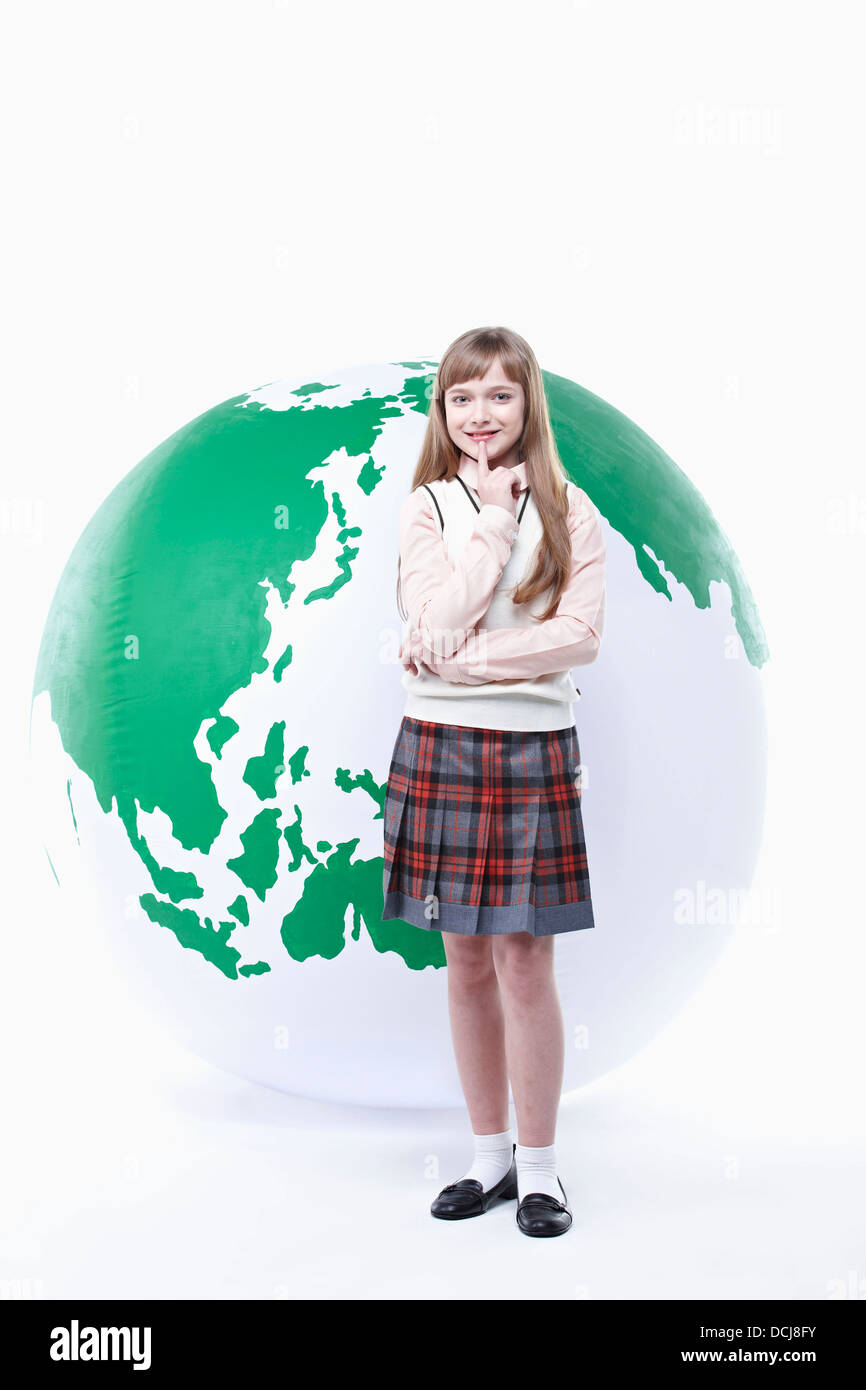 a student in uniform posing in front of a globe Stock Photo - Alamy