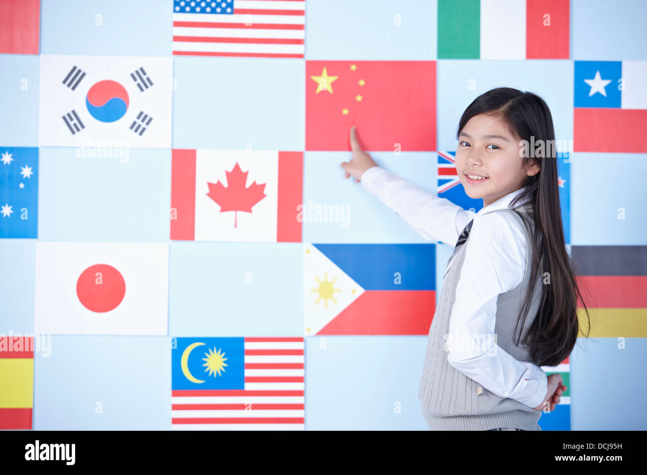 a student in uniform pointing at one of international flags Stock Photo ...